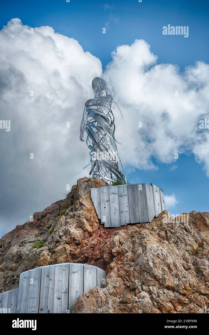 CANAZEI, ITALY - JULY 24, 2024: Metallic statue of a woman standing at ...