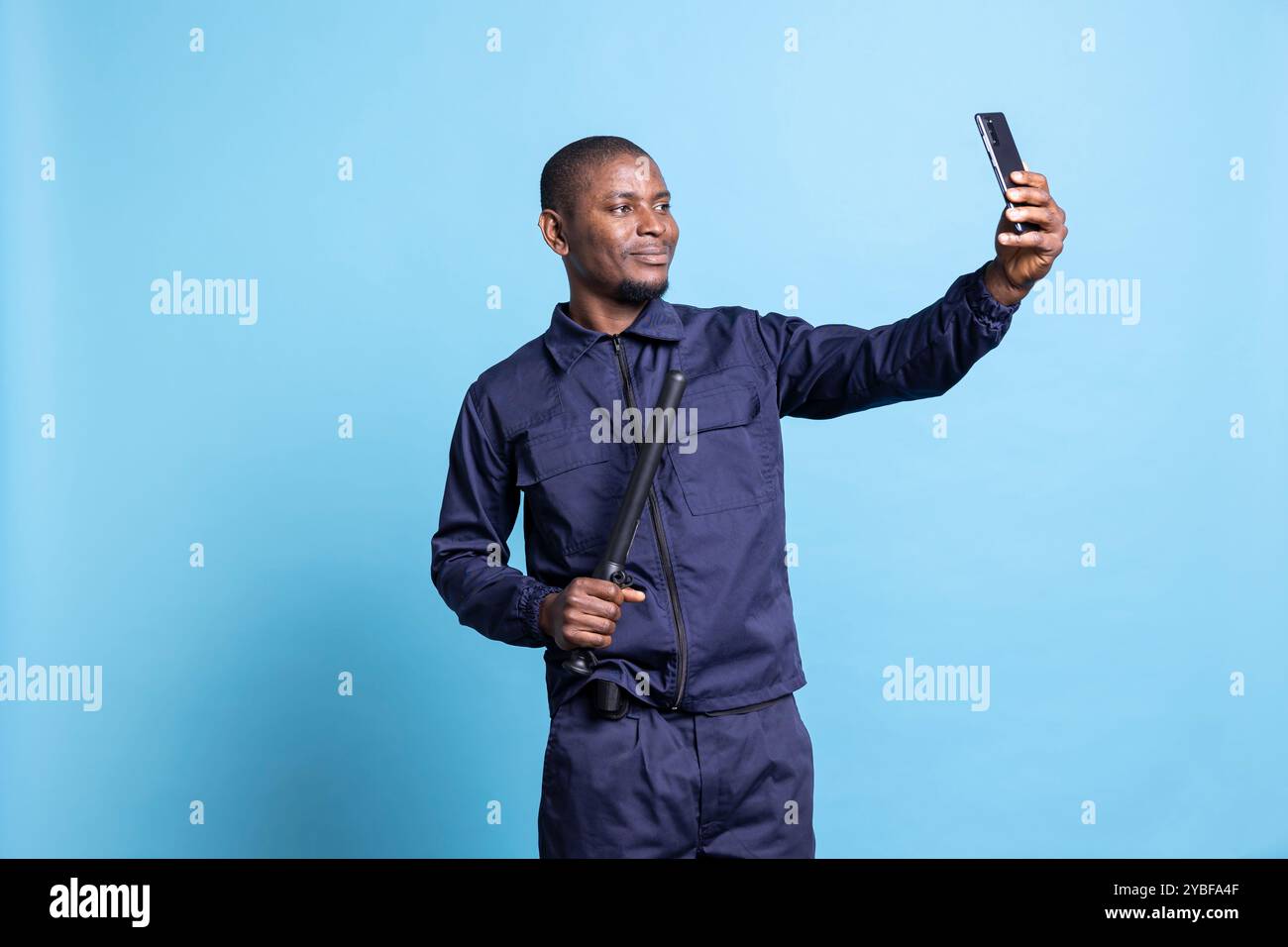 Serious security guard enjoys taking pictures with his baton against ...