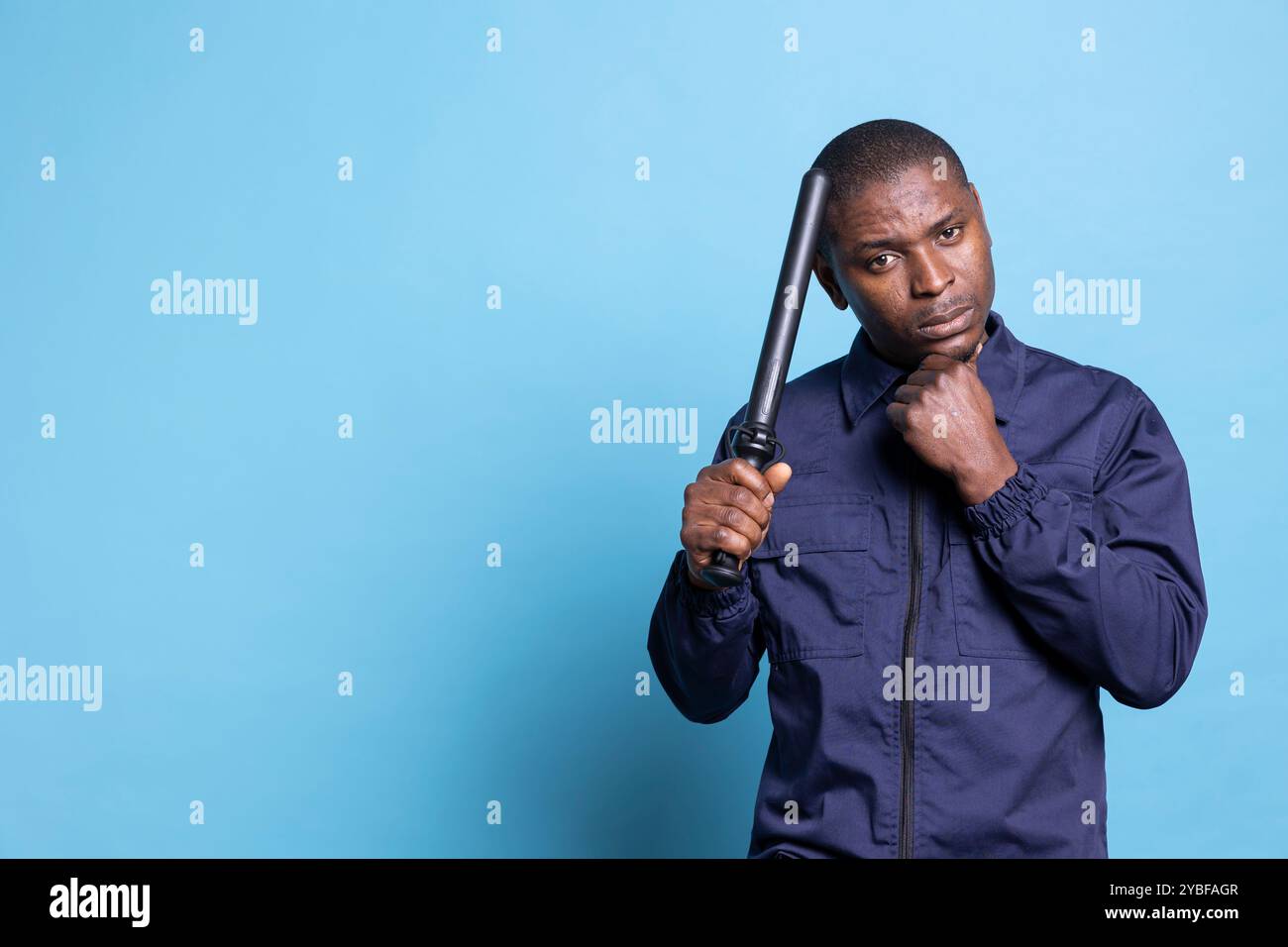 Dangerous skilled bodyguard posing with his baton weapon and clenched ...