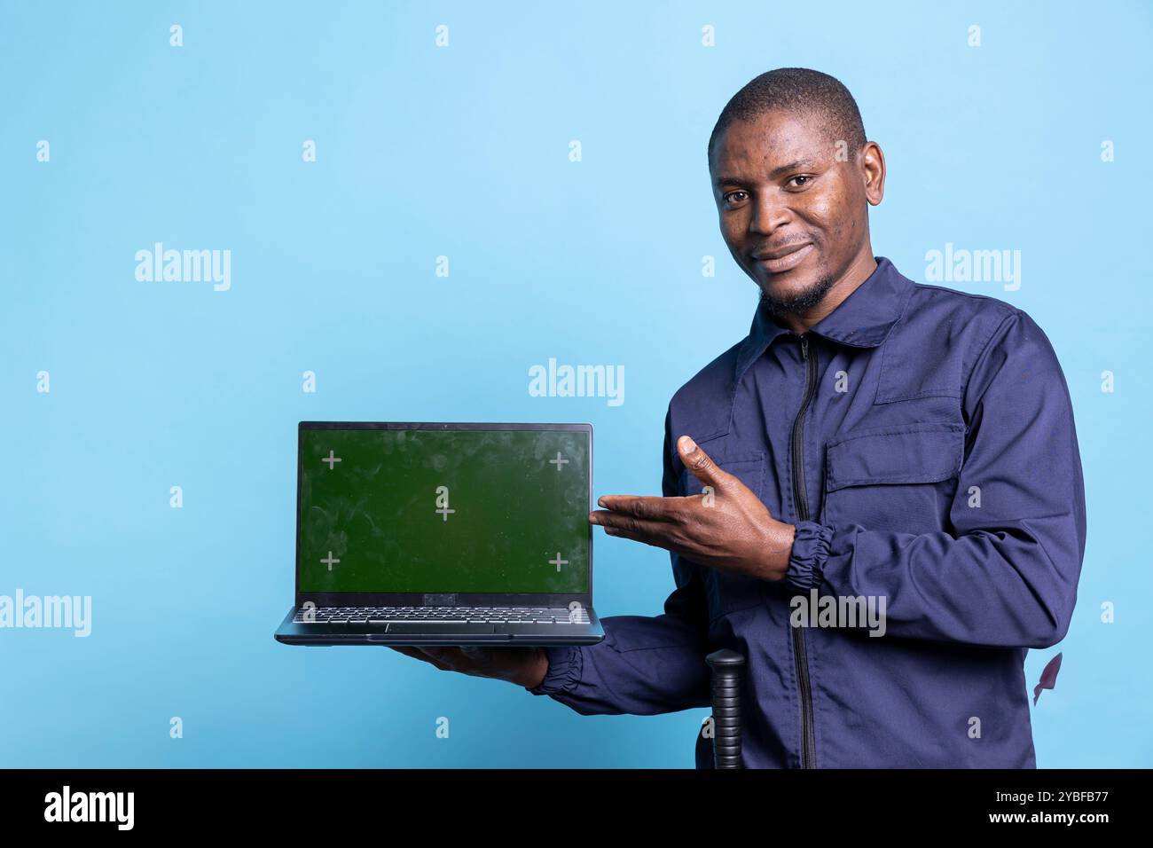 Smiling security guard pointing at his laptop with isolated copyspace ...