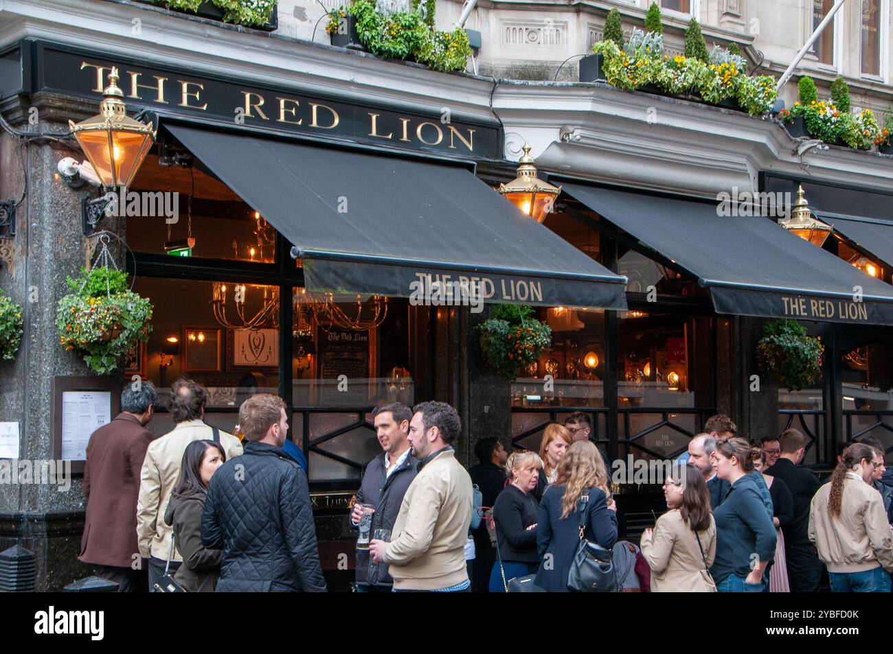 Patrons of the historic The Red Lion pub gather outside to drink and ...