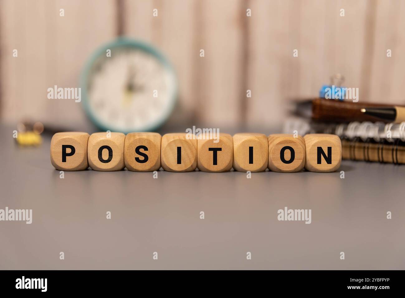 word position made from wooden gray letters lies on a blue background ...