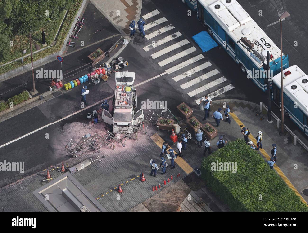 Police officers investigate a vehicle believed to have crashed into the ...