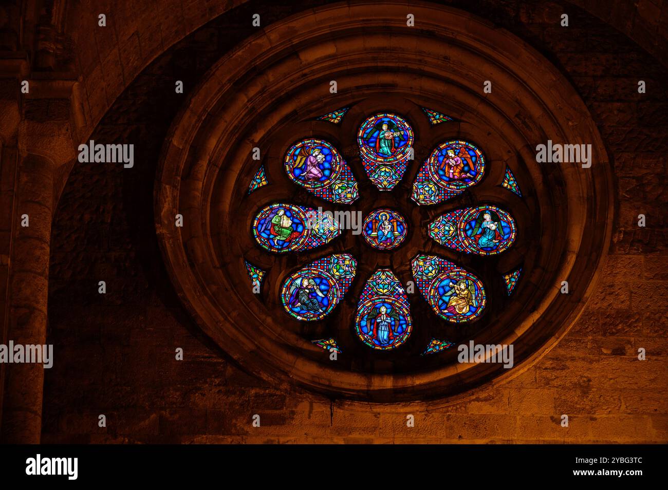 A circular stained-glass window depicting the Virgin Mary with Child in ...