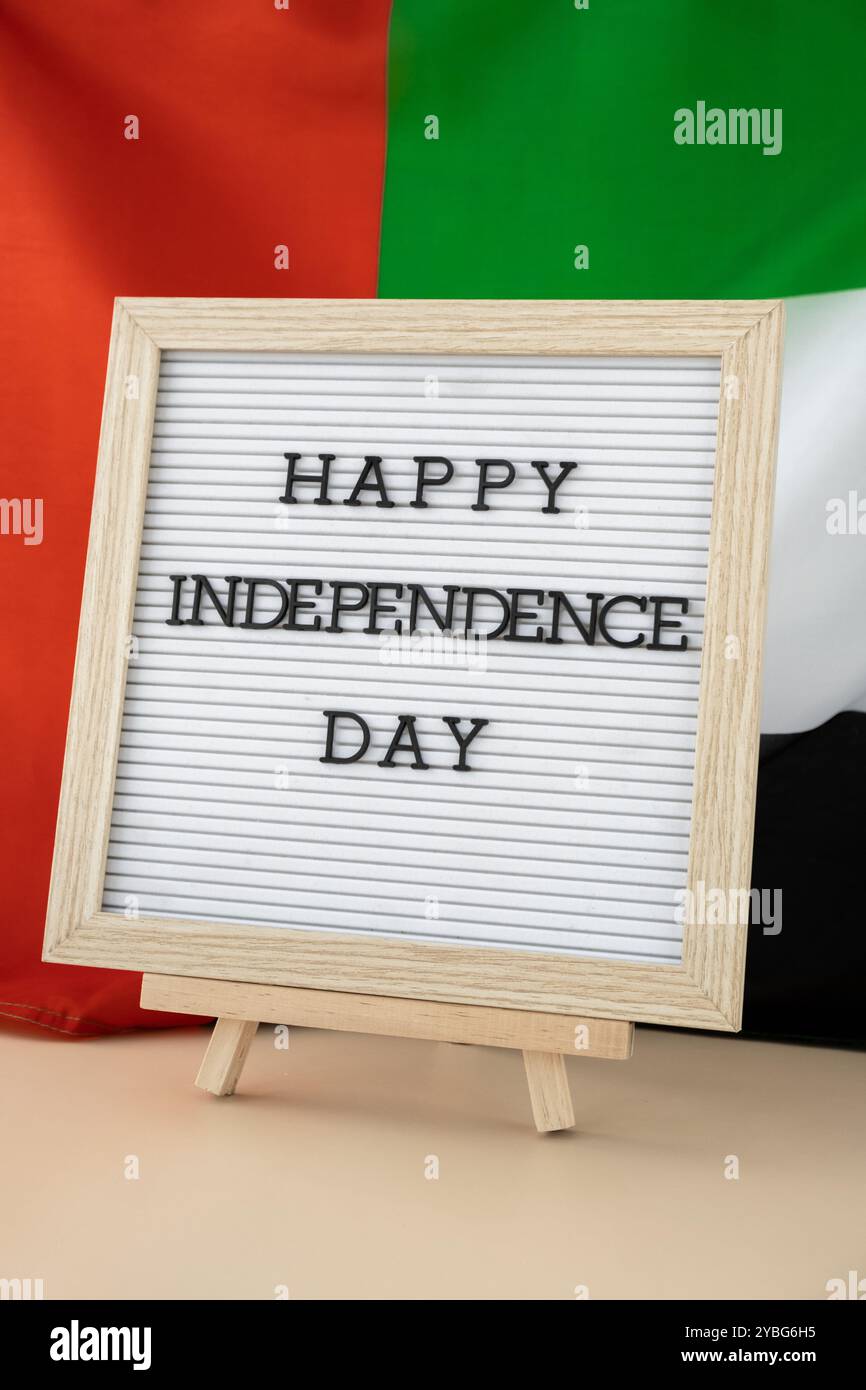 Text HAPPY INDEPENDENCE DAY on background waving flag of UAE. National ...
