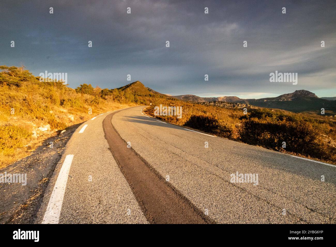Road at sunrise with a darker line of new tarmac standing out from the ...