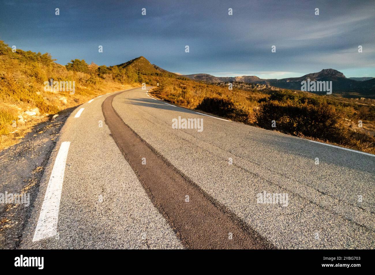 Road at sunrise with a darker line of new tarmac standing out from the ...