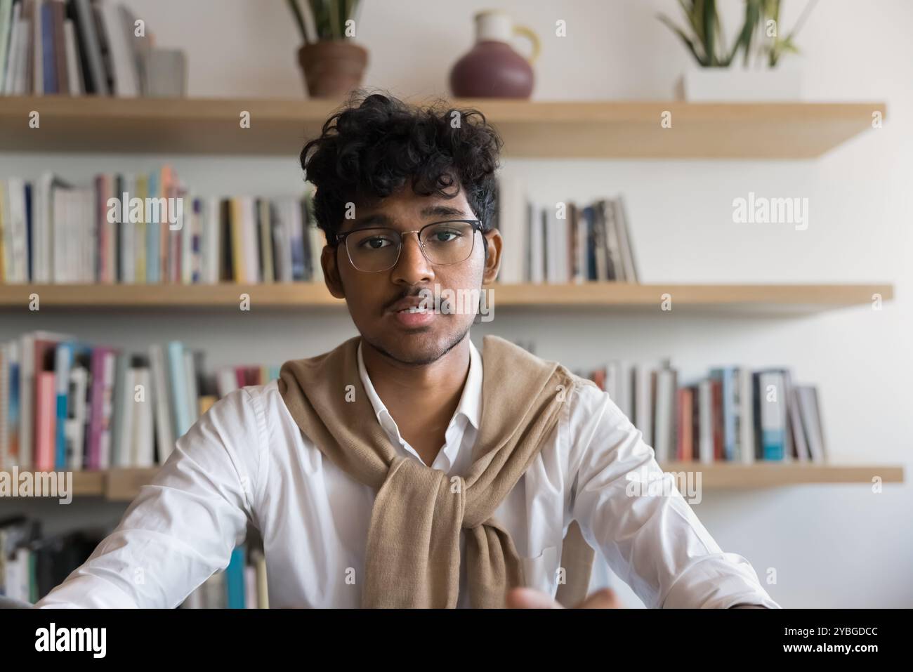 Serious Indian student guy speaking from screen on online conference ...