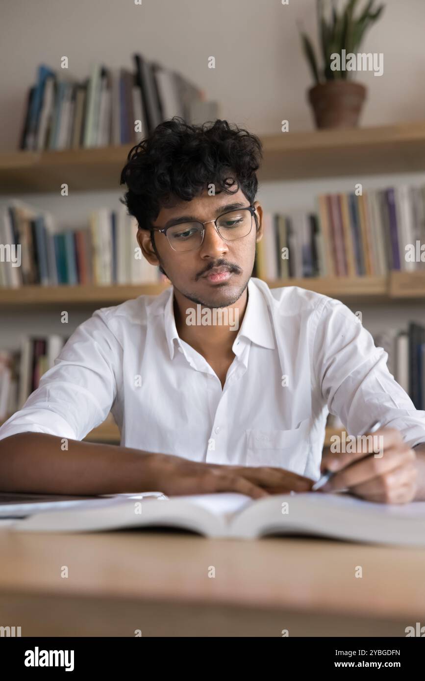 Serious young Indian student guy working on scientific article Stock ...