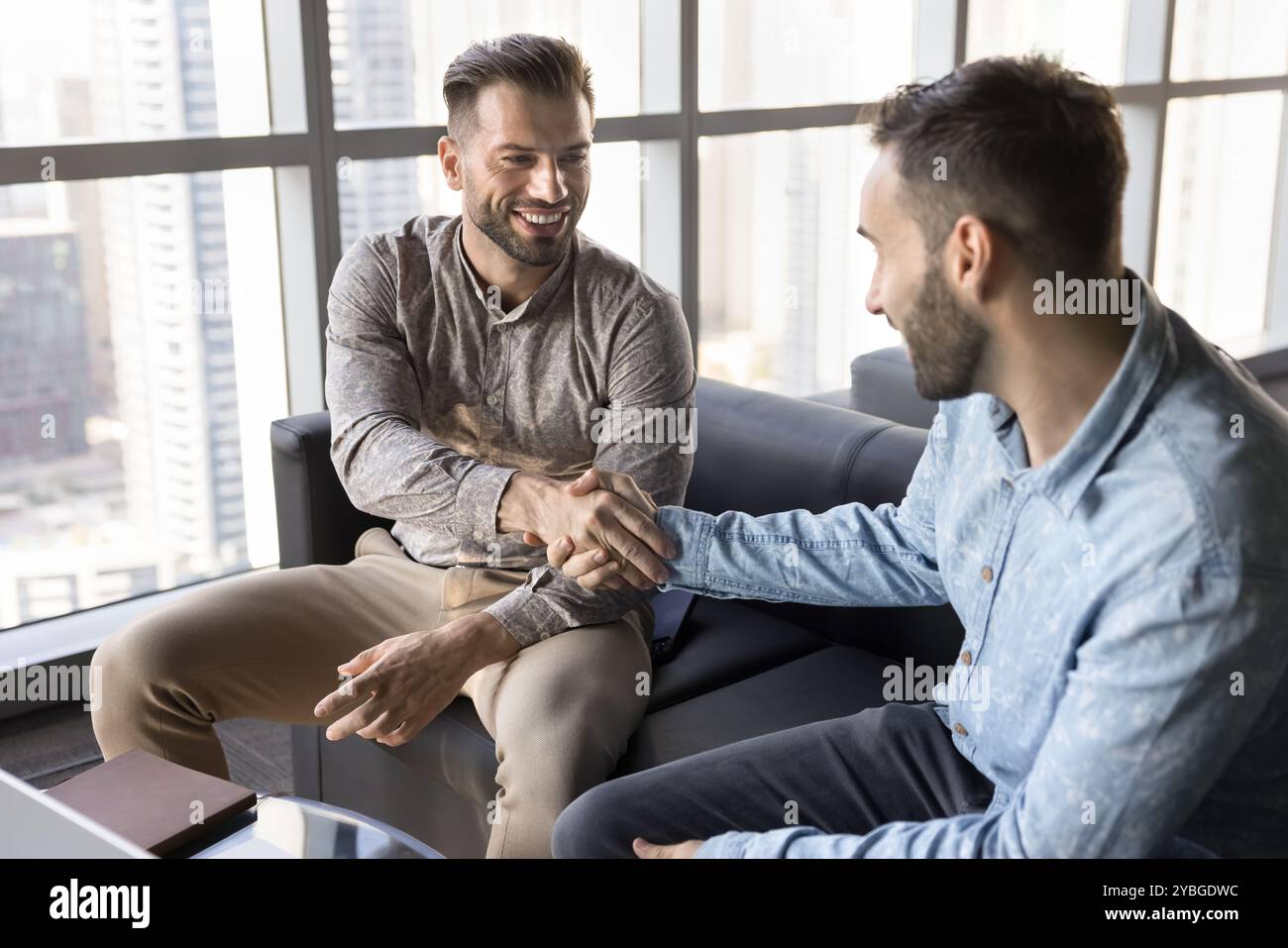 Positive confident business man giving handshake to male colleague ...