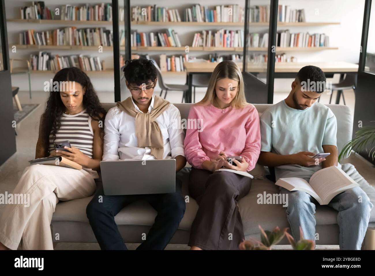 Diverse group of silent focused serious students sitting close together ...