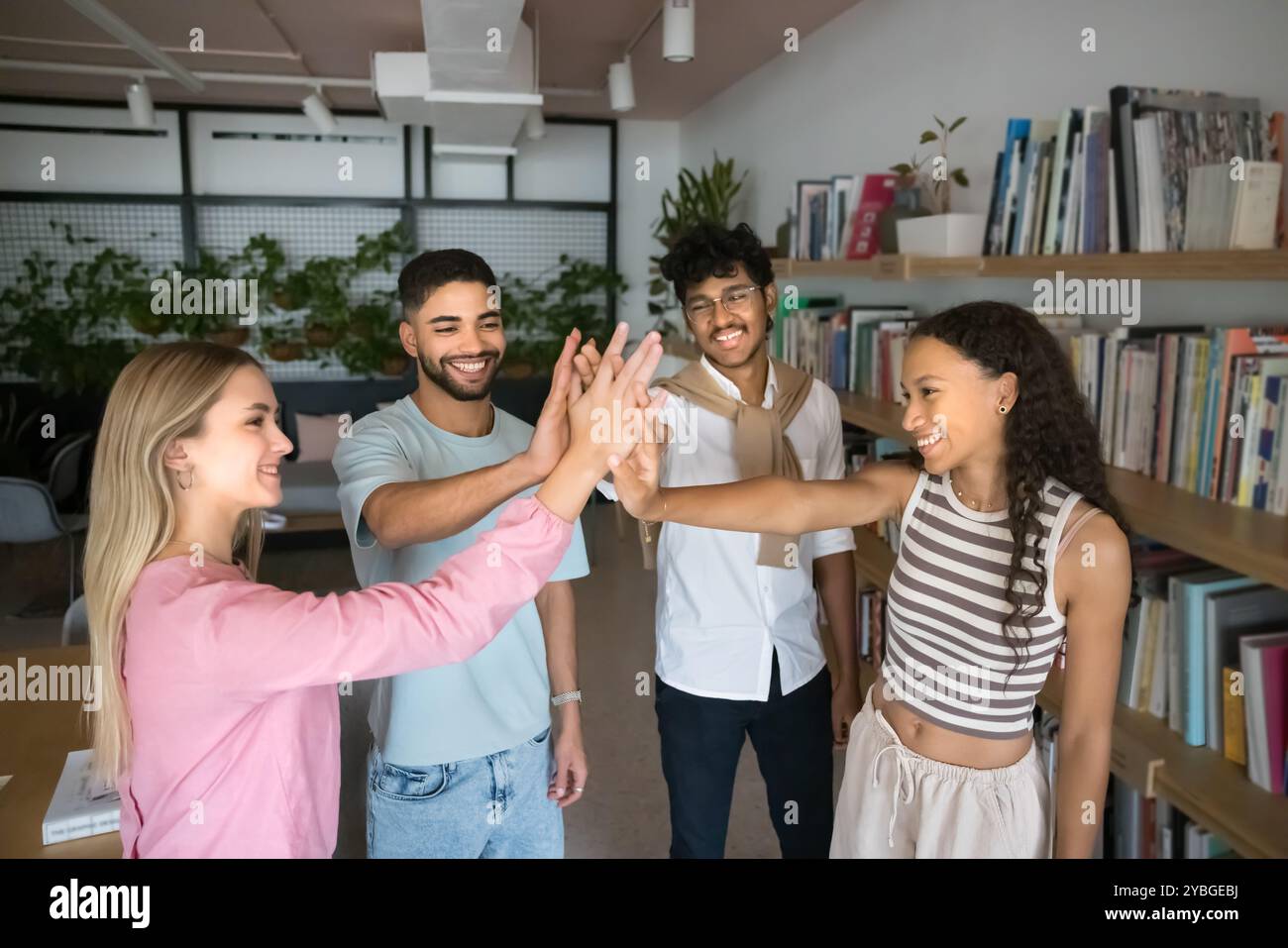 Diverse group of young students, college classmates giving high five ...