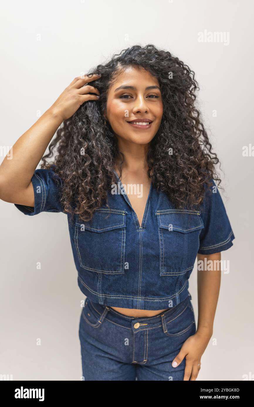 Vertical three quarter length portrait of a latin beauty woman touching ...