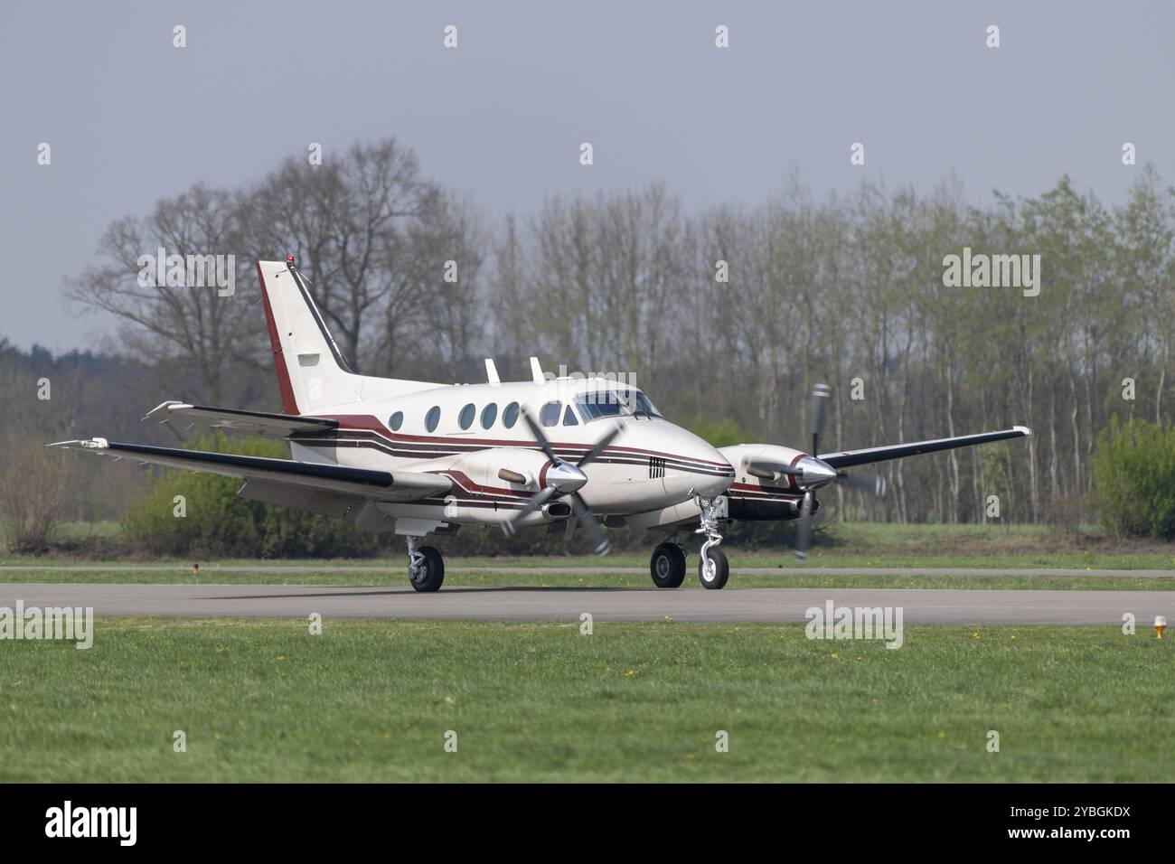 Twin-engined propeller business plane during landing at a small airport ...