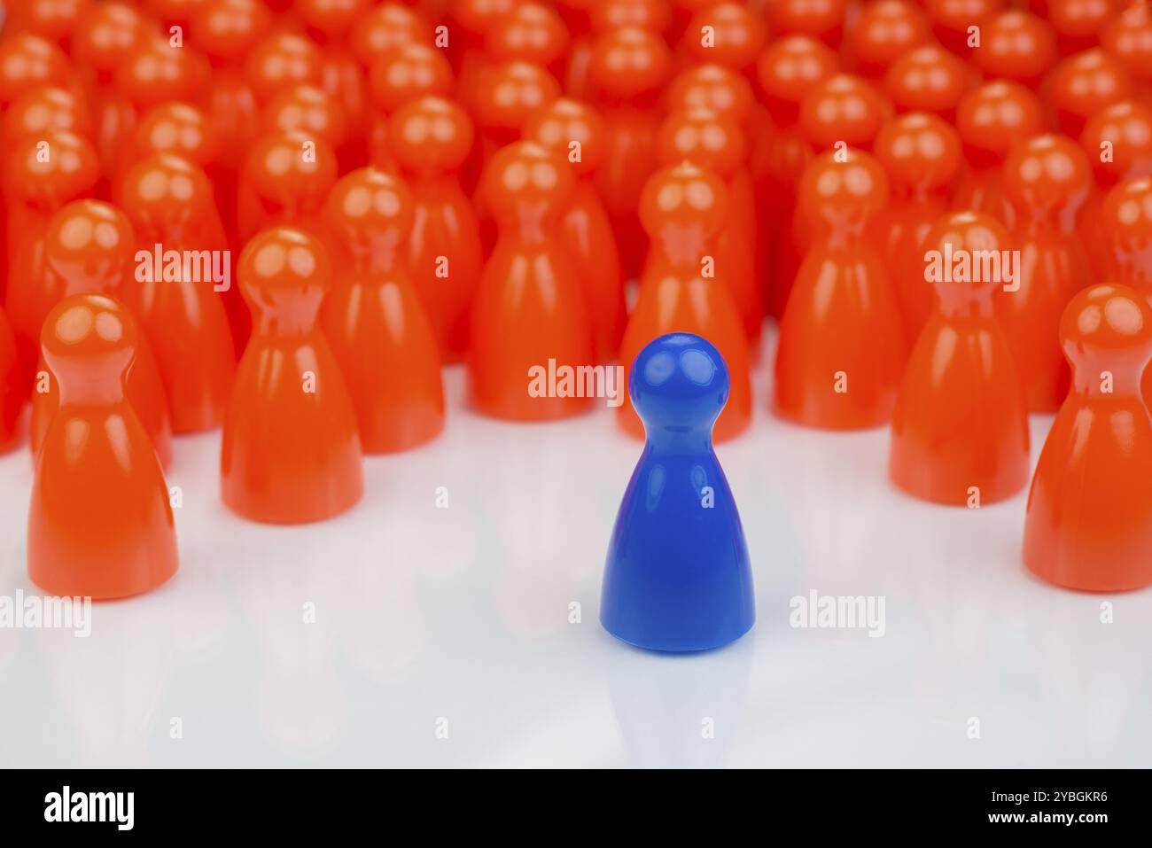 Conceptual orange game pawns and a blue play pawn as abstract display ...