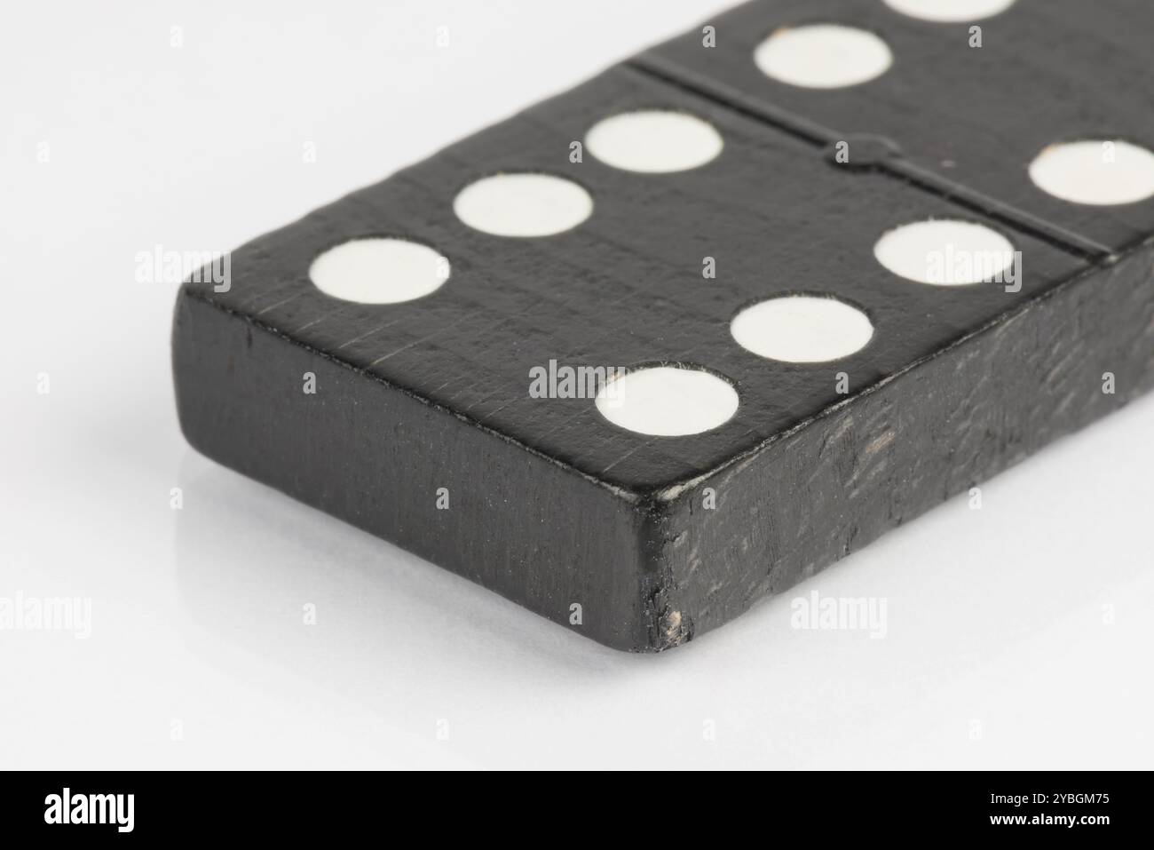 Lying black domino brick with white dots Stock Photo - Alamy