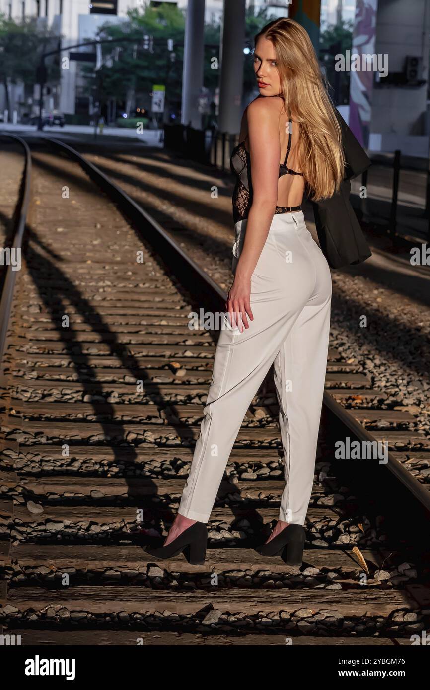 A gorgeous blonde model poses on railroad tracks at sunset Stock Photo ...