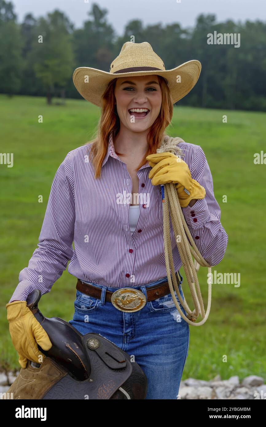 A beautiful redhead model poses in a country setting wearing cowgirl ...