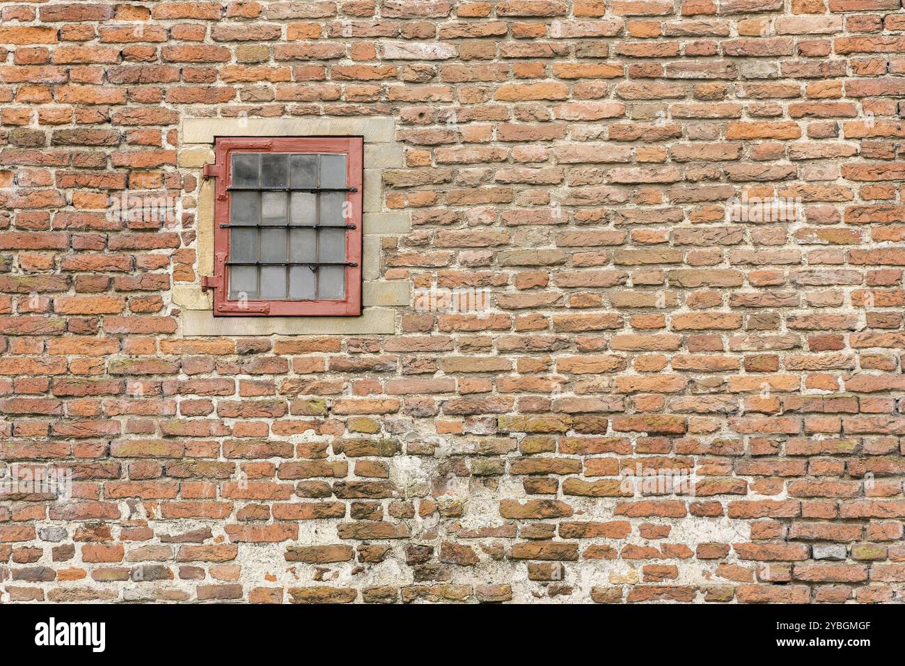 Old fortress wall with a frame and a turn window with glass rods Stock ...