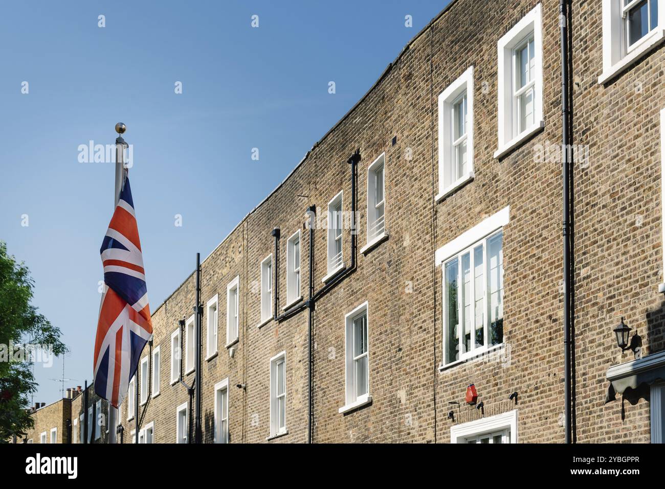 Union Jack british flag waving against typical red brick houses in ...