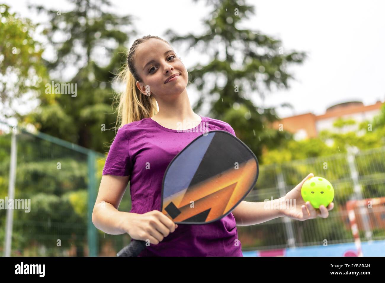 Portrait of a young pickelball woman player with racket and ball in an ...