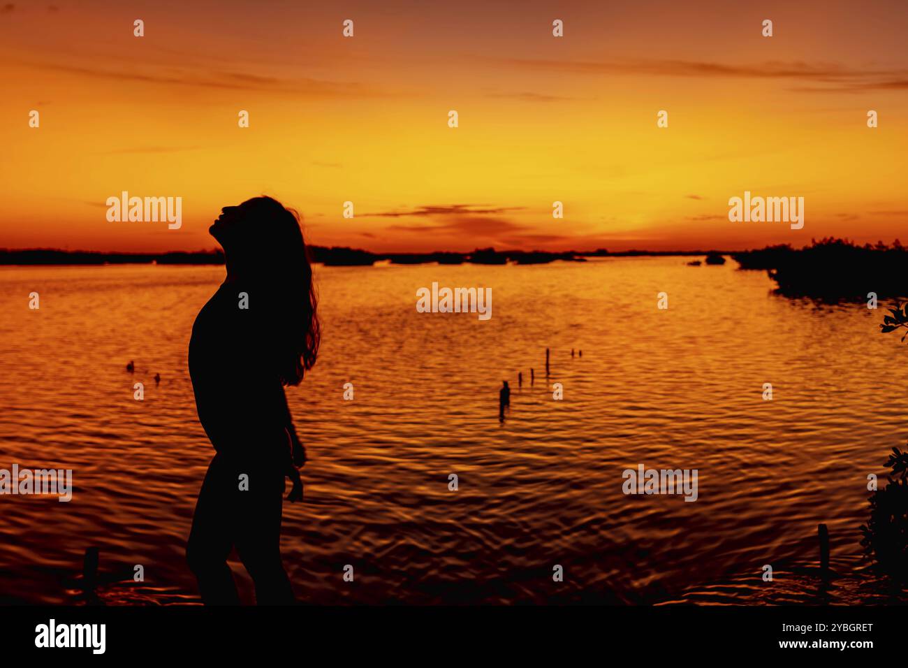 A gorgeous latin model poses as the sun rises over the Gulf of Mexico ...