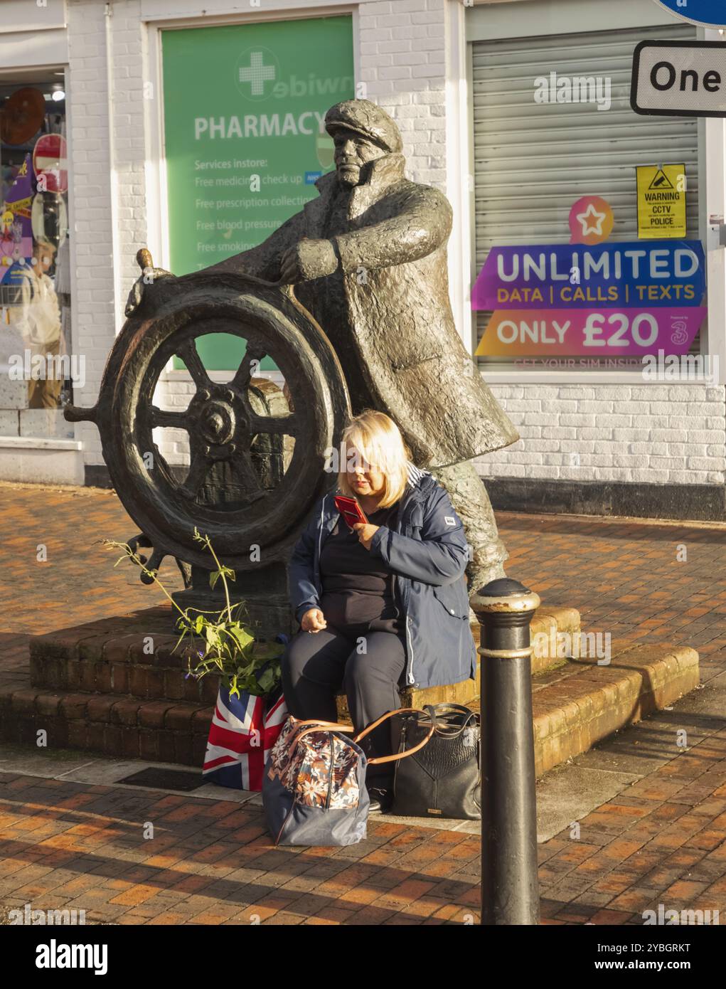 England, Kent, Sittingbourne, The High Street, Woman on Phone sitting ...