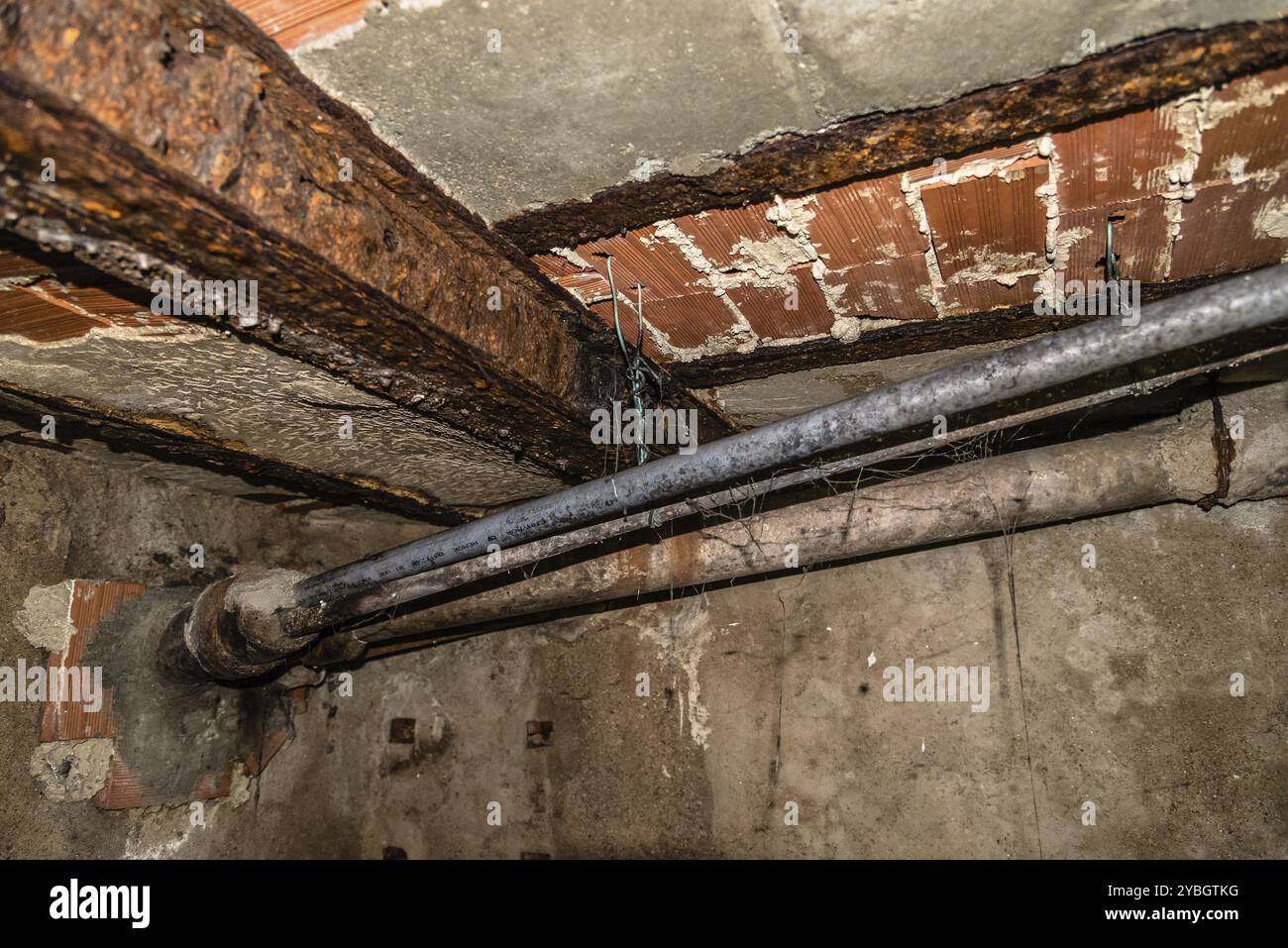 Old rusty steel structure and drainage pipes in the basement on an old ...