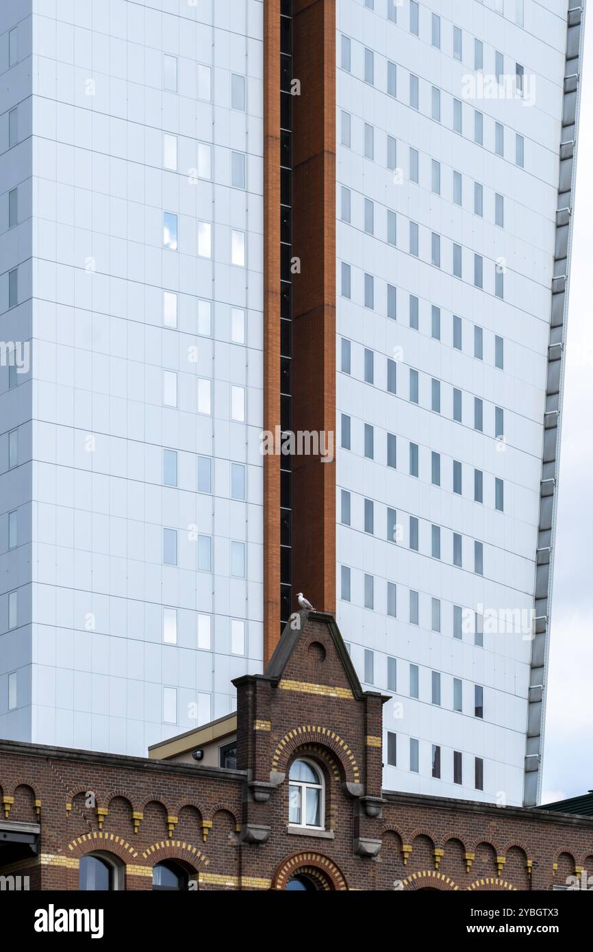 High-rise modern building juxtaposed with old architecture facade, in ...