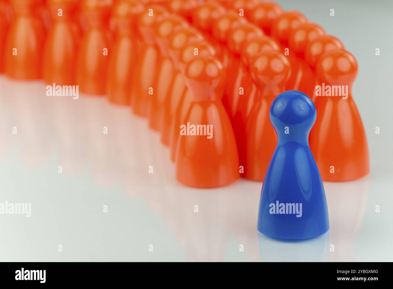 Conceptual orange game pawns and a blue play pawn as abstract display ...