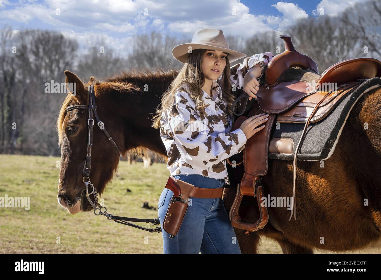 A beautiful brunette cowgirl poses with her horse before riding in the country Stock Photo - Alamy