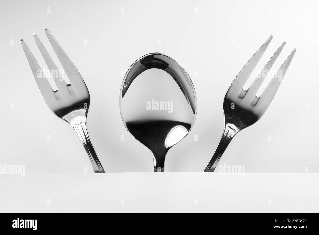 Metal spoon and two metal forks formed into a frightning conceptual ...
