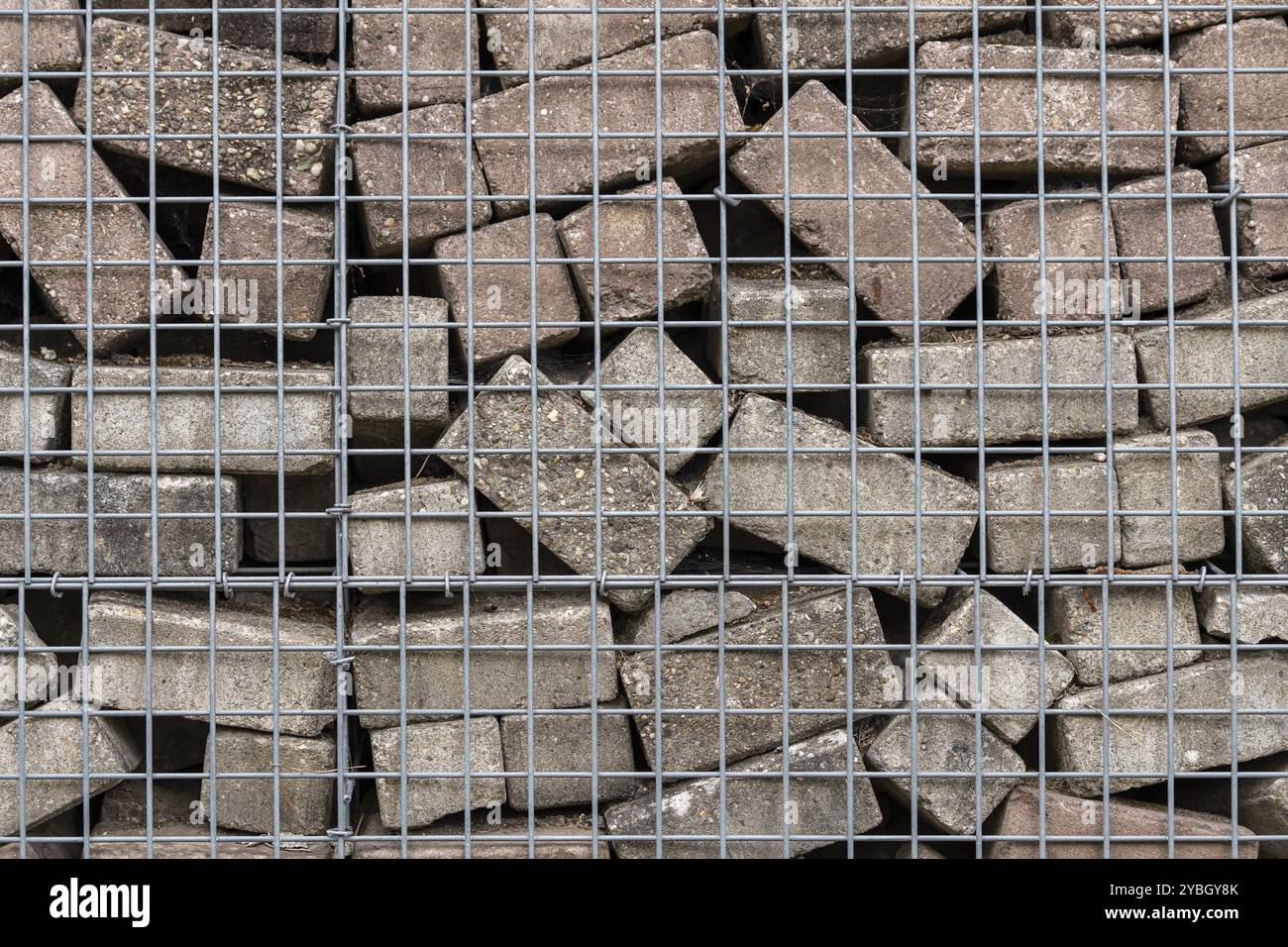Stone wall built of concrete bricks and metal mesh Stock Photo - Alamy