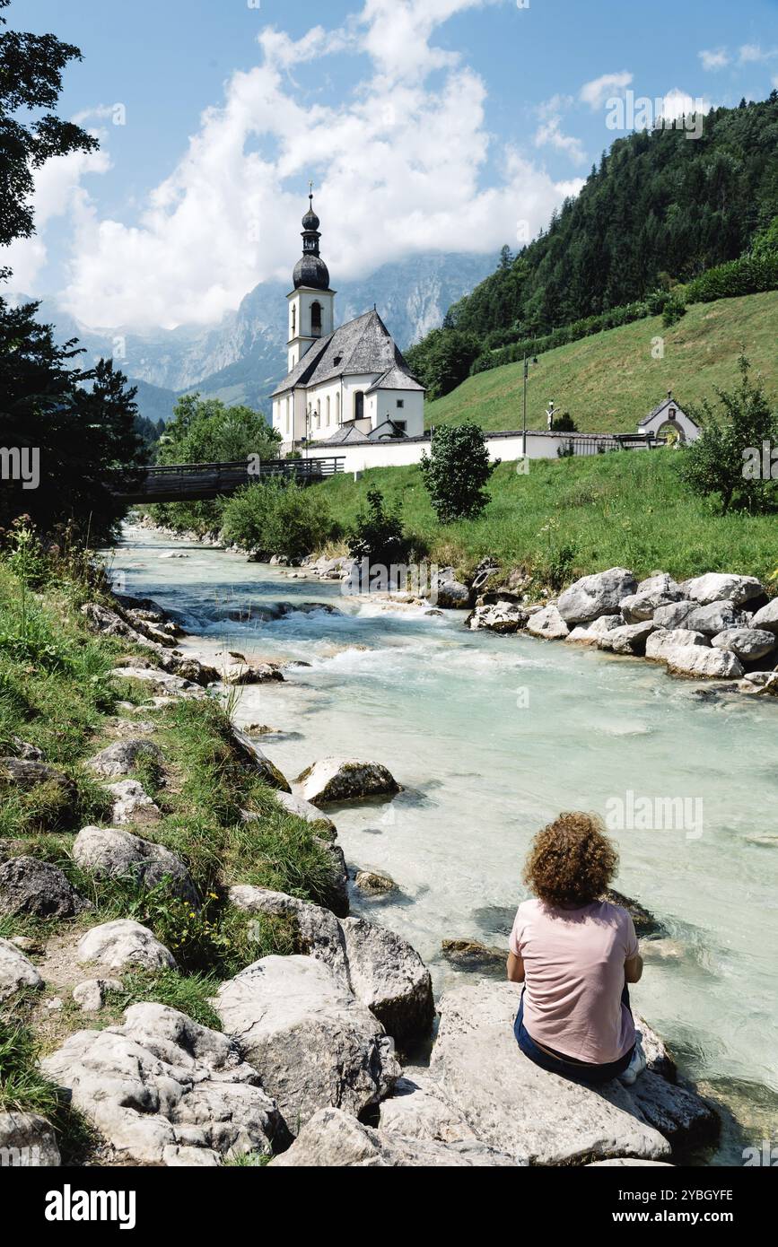 Woman sitting on a rock by a water stream in the mountain. Space for ...