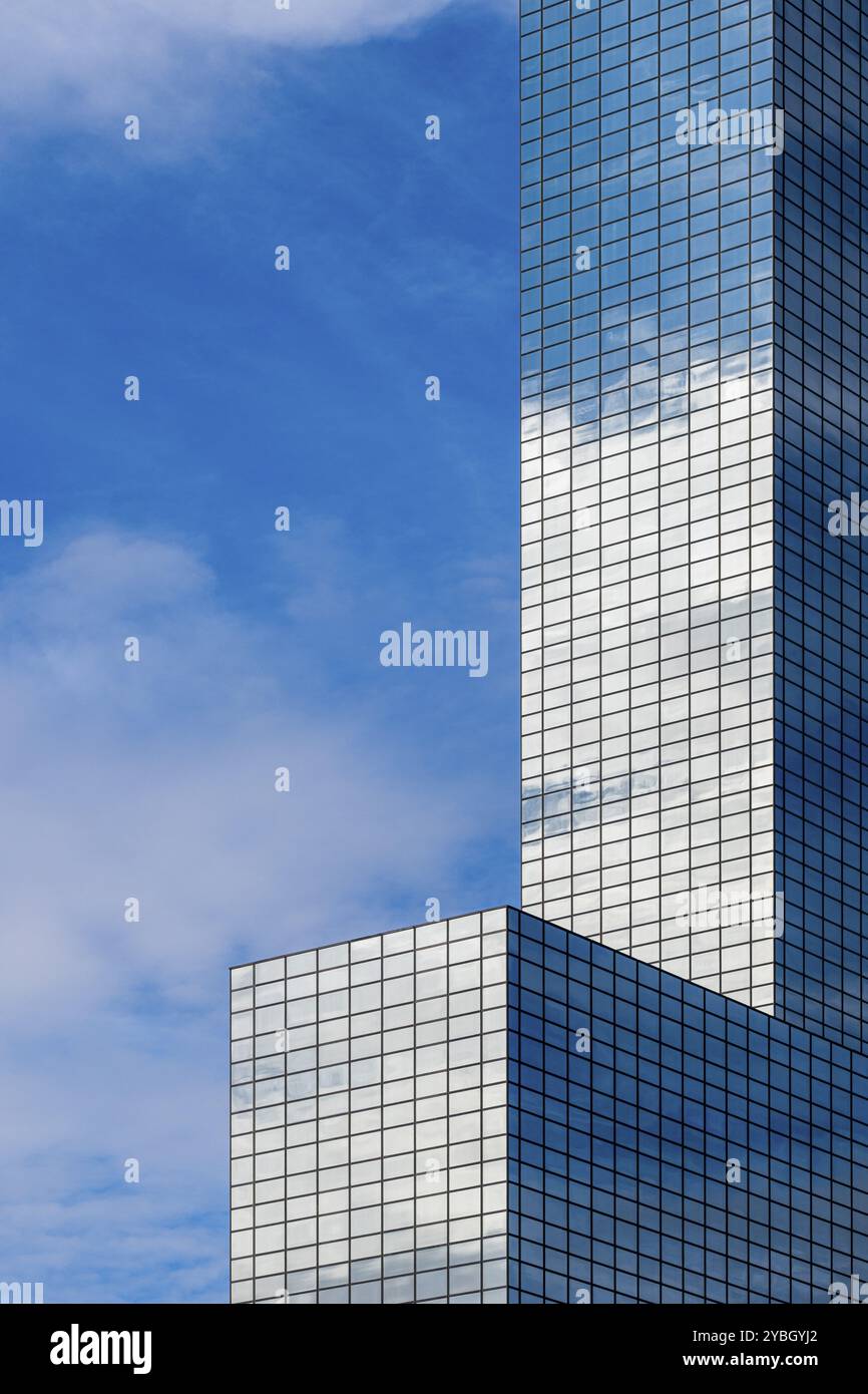 Reflective glass building with blue sky and clouds depicting urban ...