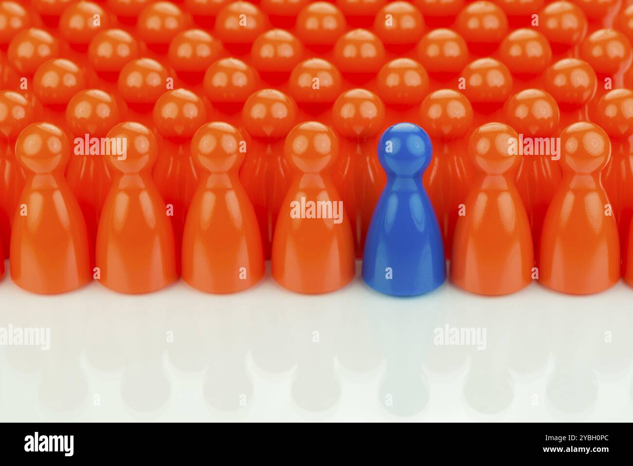 Conceptual orange game pawns and a blue play pawn as abstract display ...