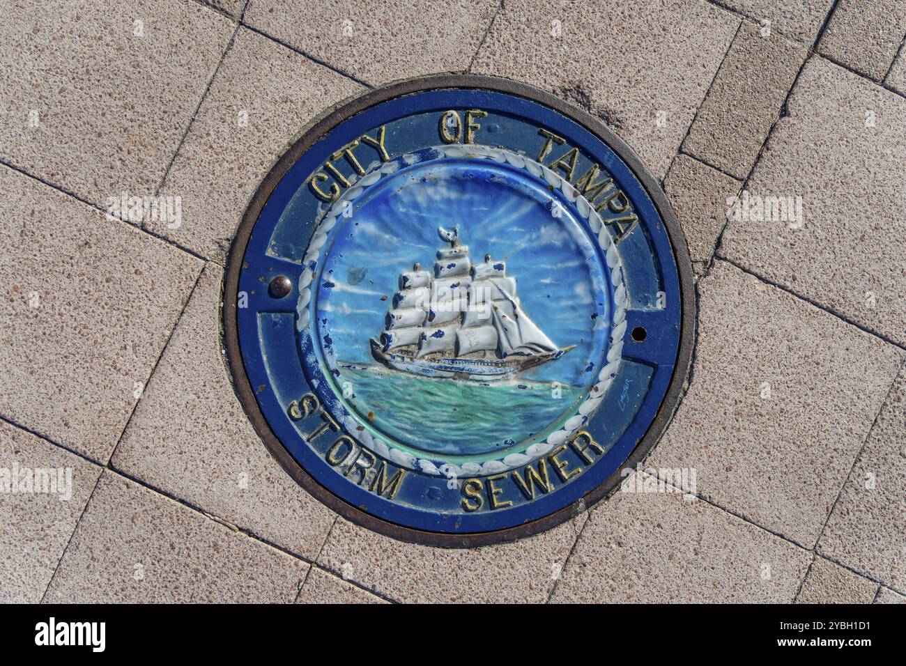 Storm sewer manhole cover on a busy street in the city of Tampa Bay Stock Photo - Alamy