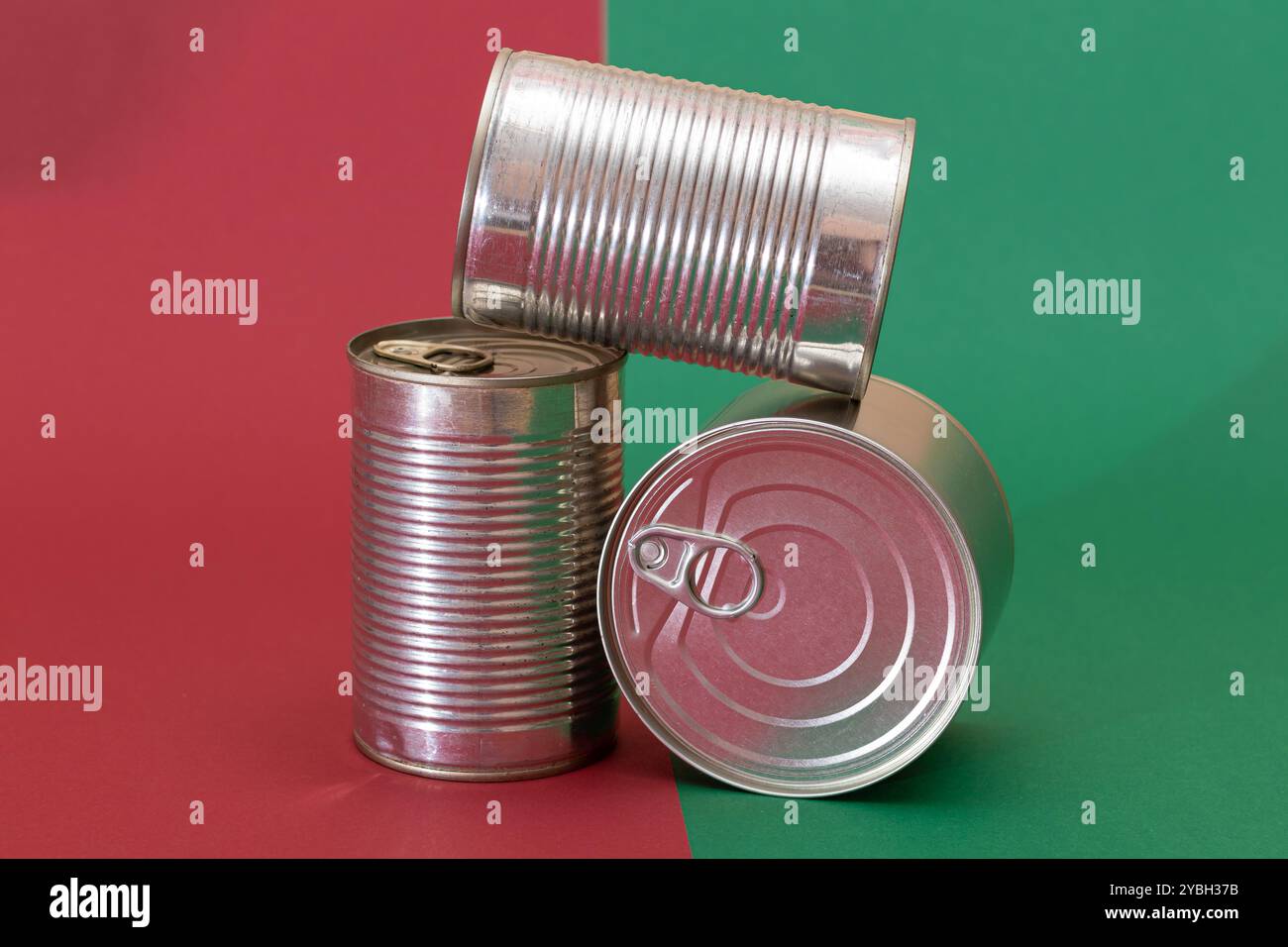 A Group of Stacked Tin Cans on Split Red and Green Background. Canned ...