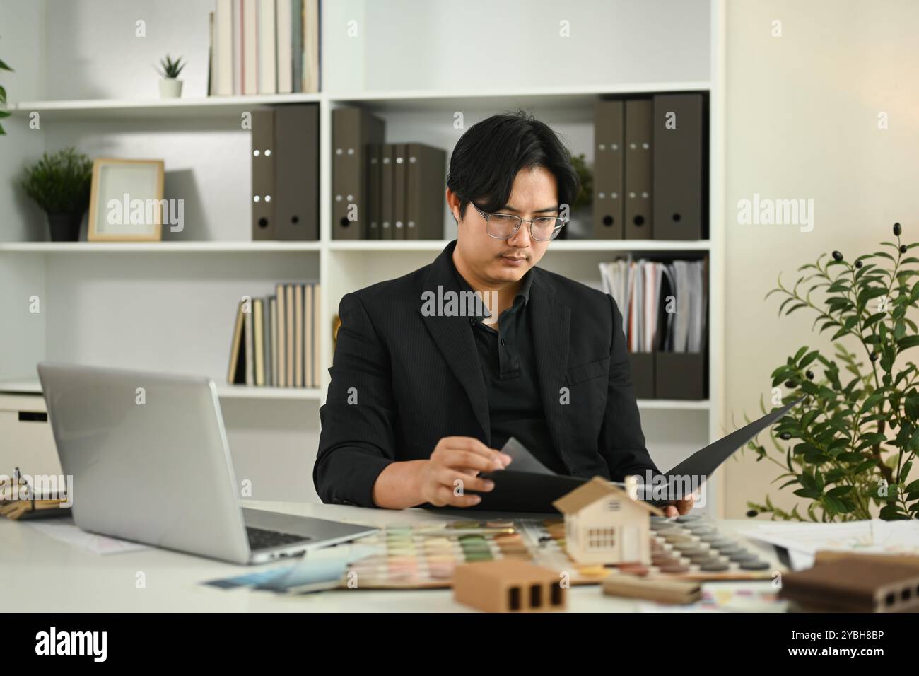 Focused interior designer reviewing material samples and design ...