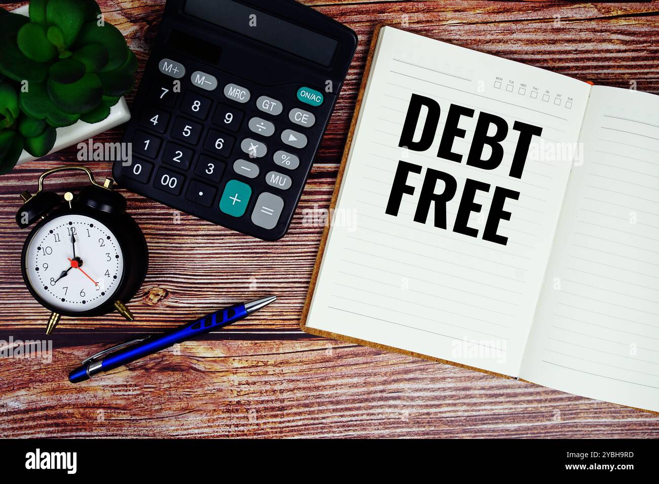 Debt Free text written on paper torn with calculaton and alarm clock ...