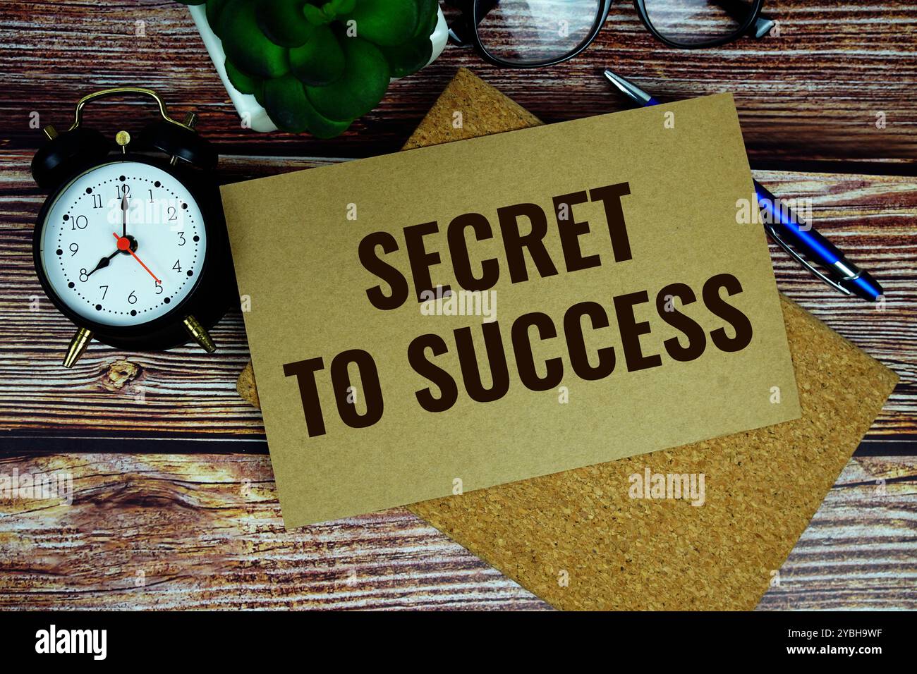 Secret to Success text written on paper torn with alarm clock top view ...