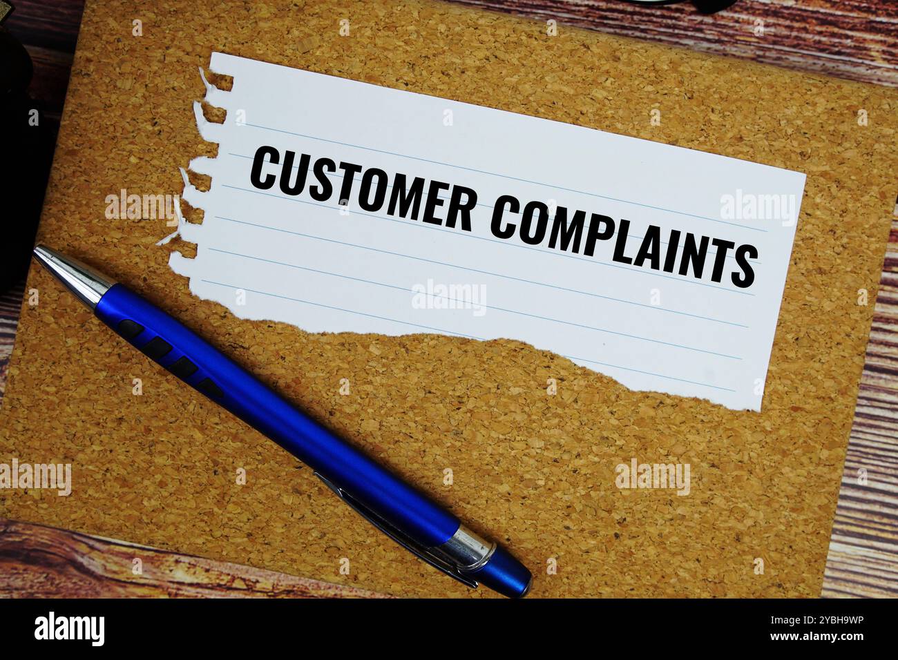 Customer Complaints text written on paper torn top view on wooden ...