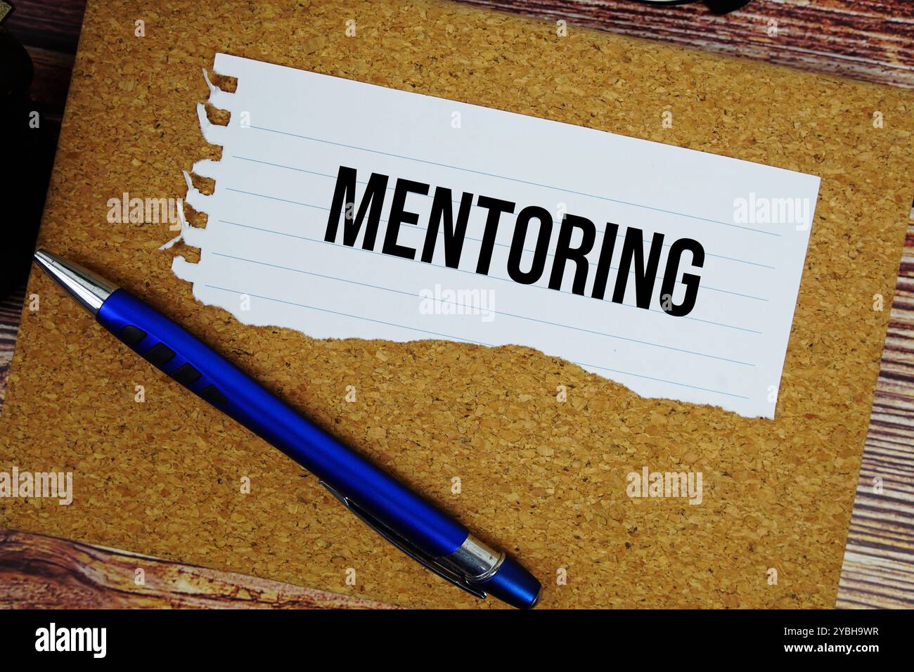 Mentoring text written on paper torn with pen top view on wooden ...