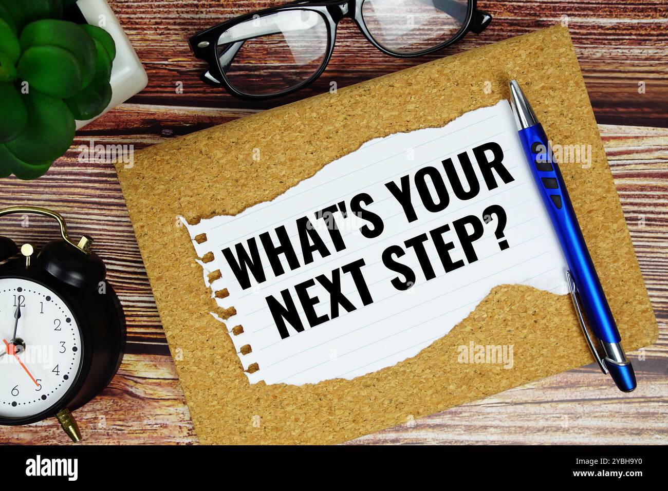 What's your next step? text written on paper torn with alarm clock top ...
