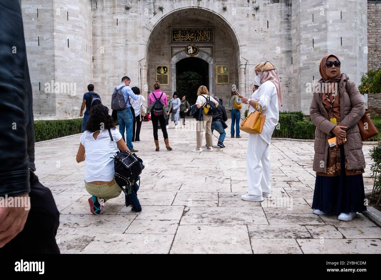 Tourist taking photos with his smartphone in front of the large Gate of ...