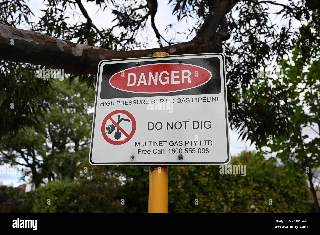Rectangular Multinet Gas Network danger sign, attached to a yellow pole ...