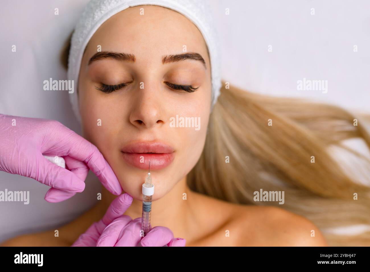 Injection procedure for lip augmentation, close-up. The cosmetologist ...