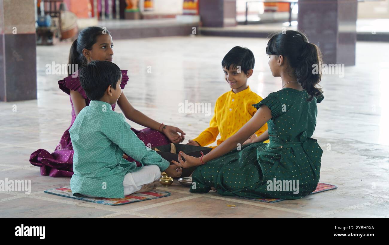 A traditional Indian family engaged in a sacred Yagya ritual to ...