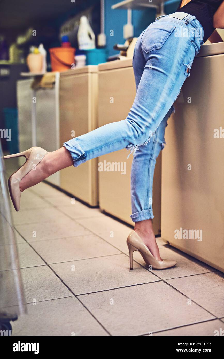 Legs, chores and person in laundry room, routine and loading in washing ...