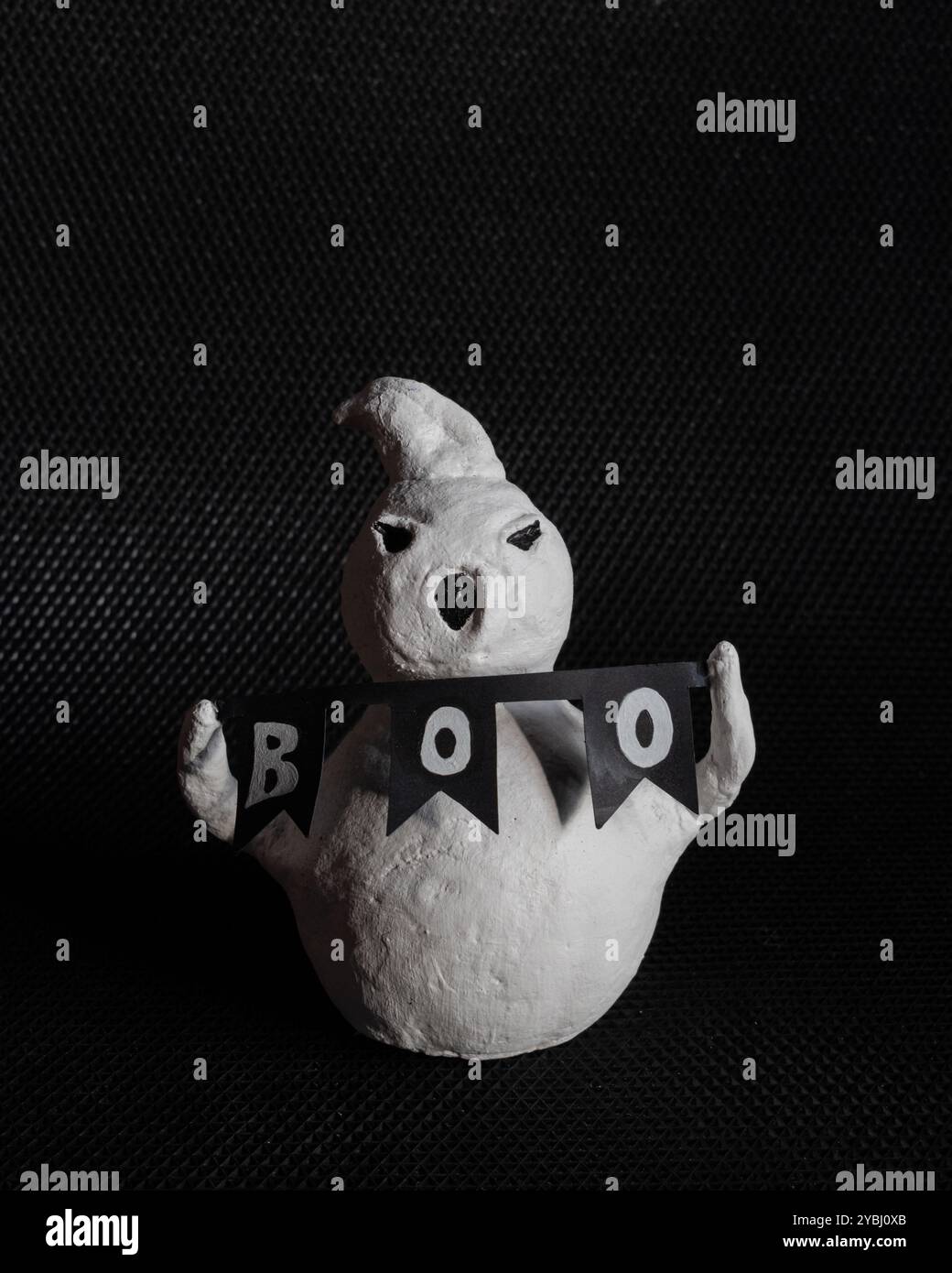 Little vintage screaming white ghost holding boo banner on black ...